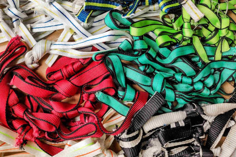 How do webbing knots influence the breaking strength?